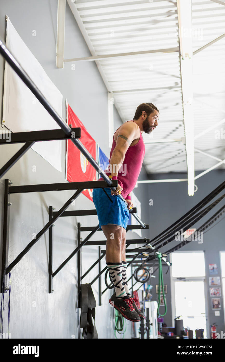 Mixed Race man working out on bars in gymnasium Stock Photo - Alamy