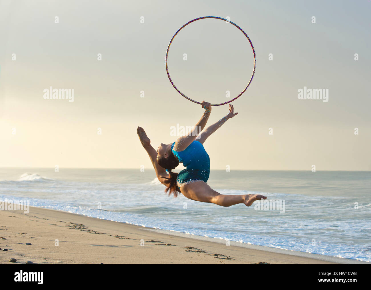 Caucasian gymnast jumping with hoop on beach Stock Photo - Alamy