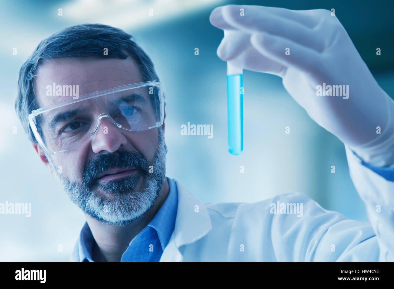 Hispanic researcher holding vial of blue liquid Stock Photo - Alamy