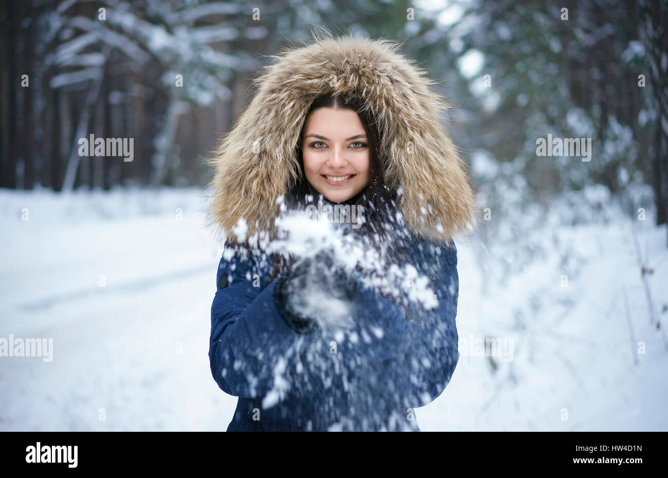Portrait of playful Caucasian woman throwing snow Stock Photo - Alamy