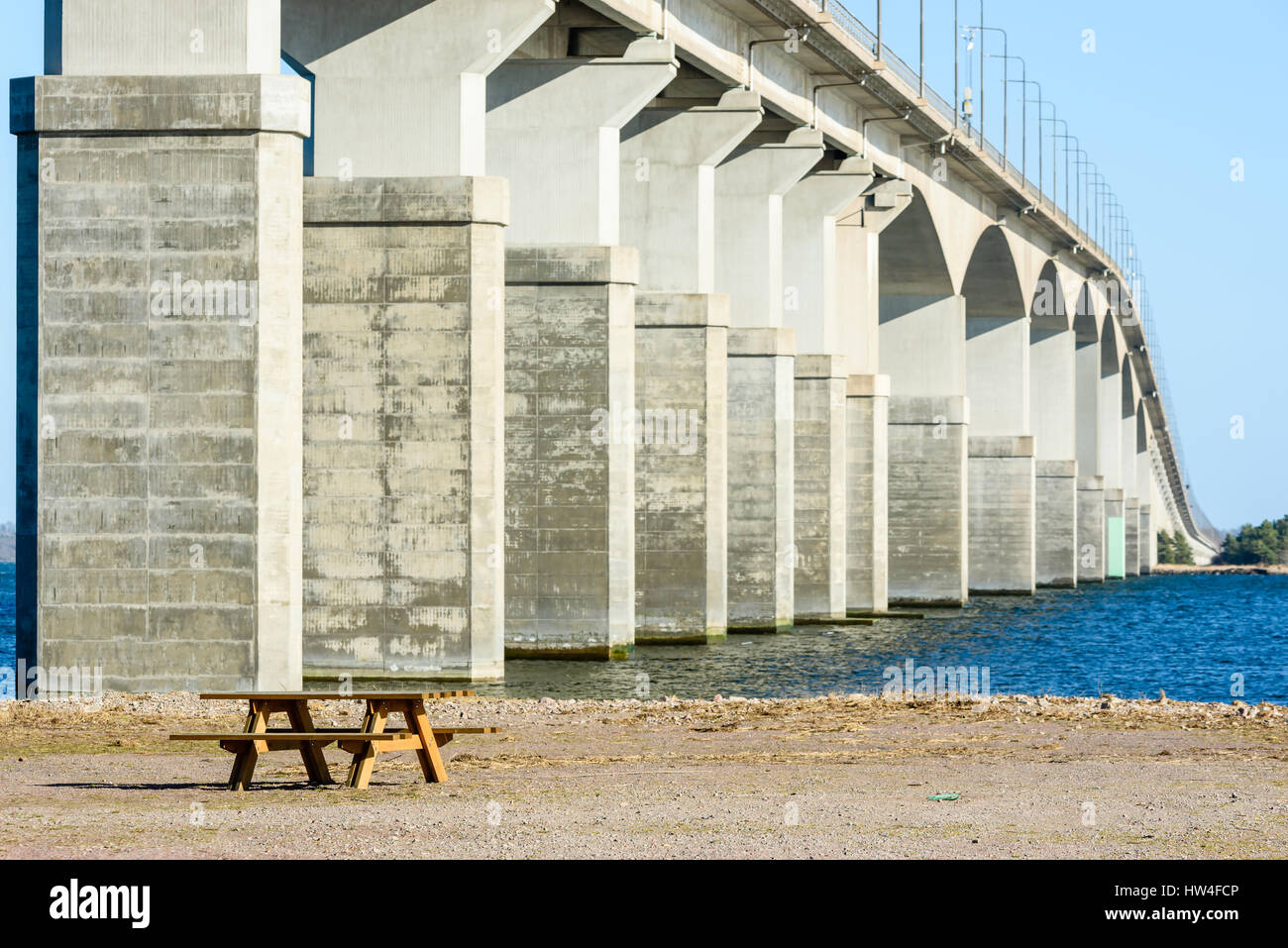 Empty bench under concrete bridge. Gray pillars support the weight of ...