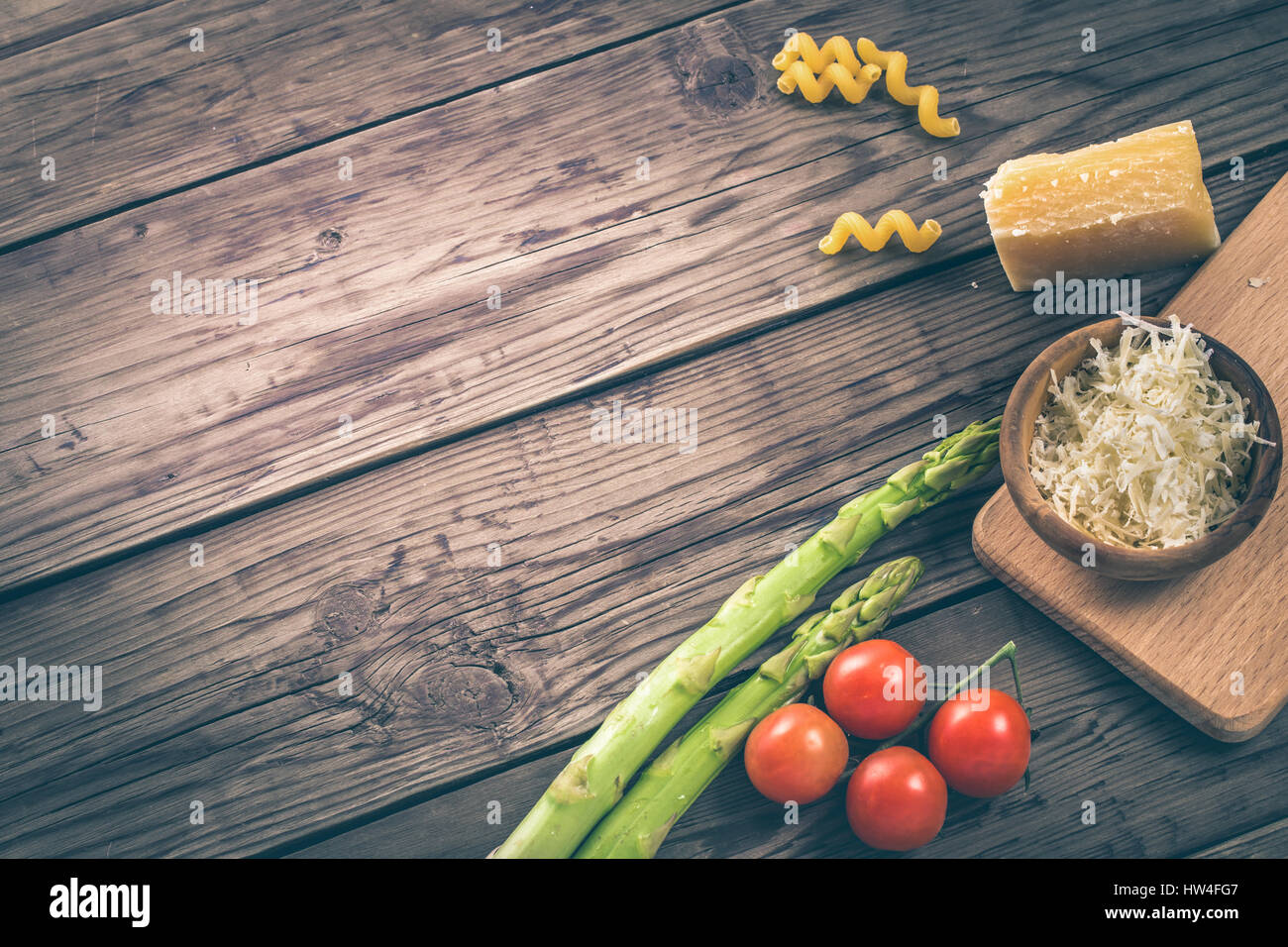 Rustic wooden food background with asparagus and cheese. With copy ...