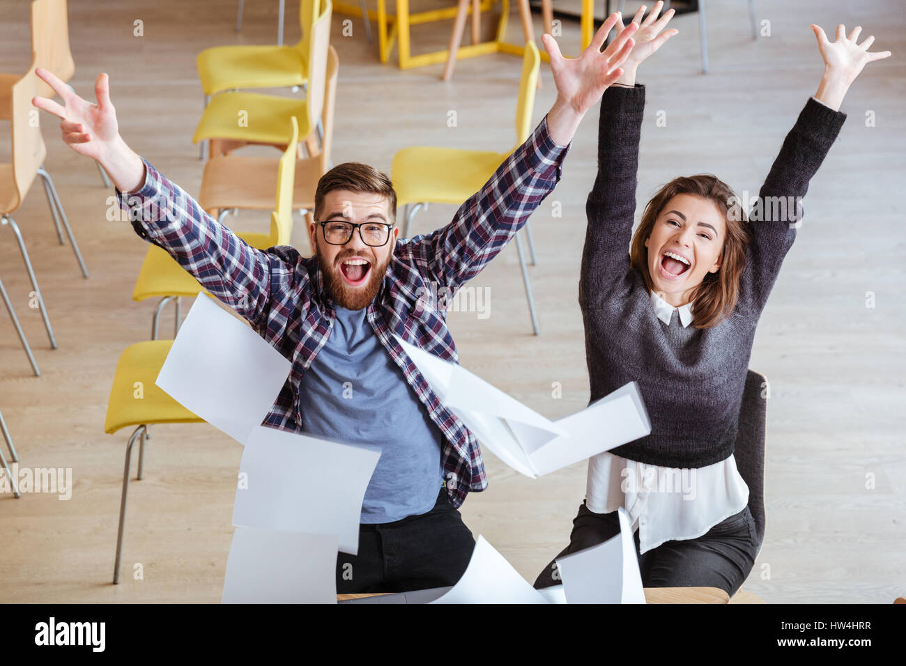 Top view of happy cheerful students having fun in library by throwing ...