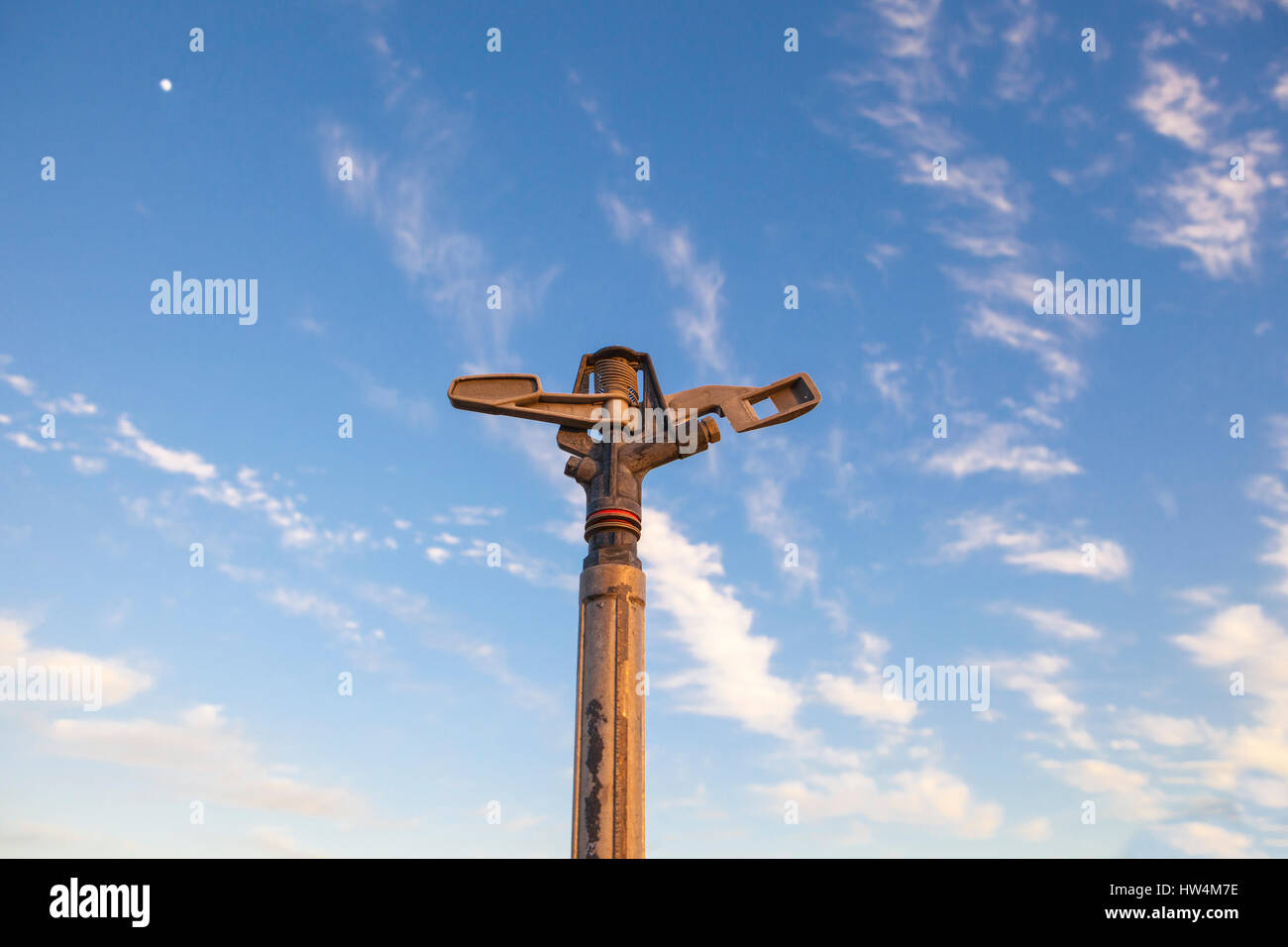 Closeup of a water sprinkle over blue cloudy sky with moon Stock Photo ...