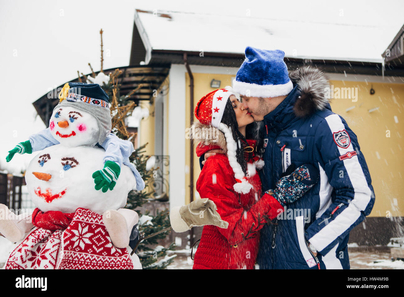 happy couple with snowman Stock Photo - Alamy