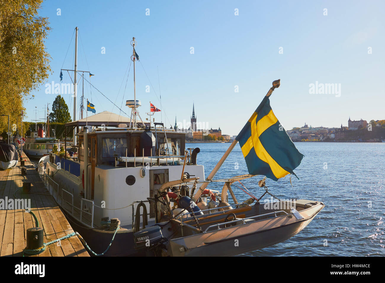 Swedish flag on boat on Kungsholmen waterfront with Riddarholmskyrkan ...