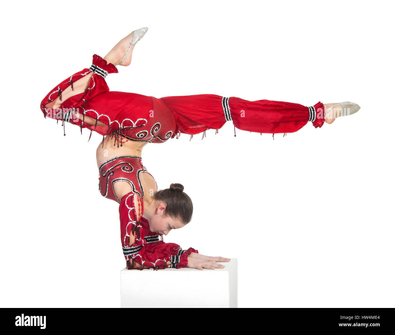 A young woman in stage costume shows gymnastics. Studio shooting stage ...