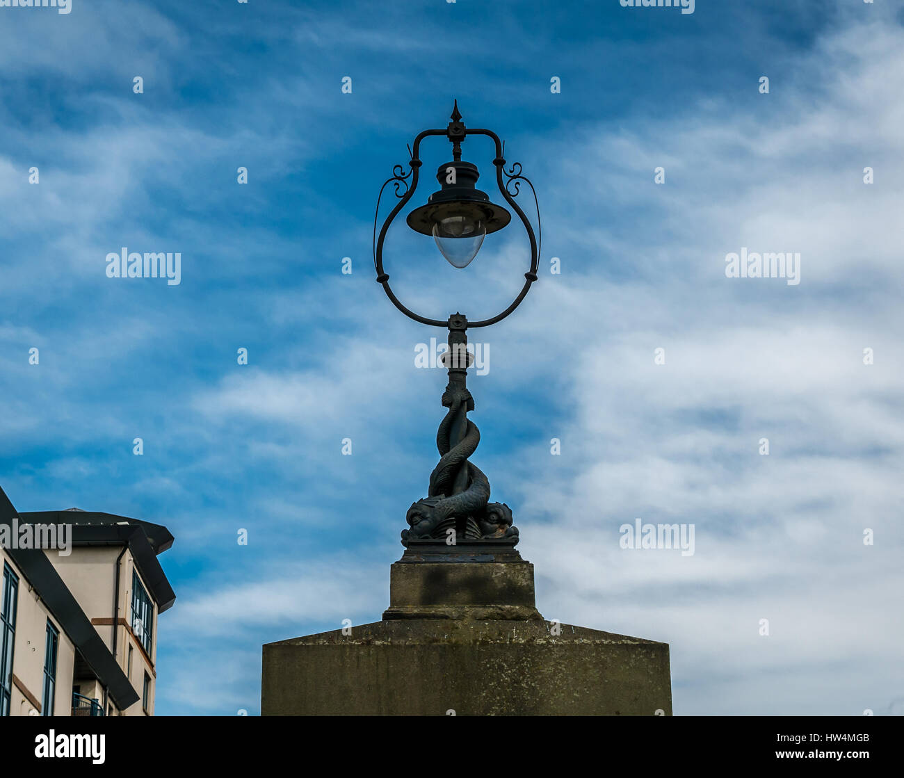 Old decorative street light with fantastical coiled fish sculpture ...