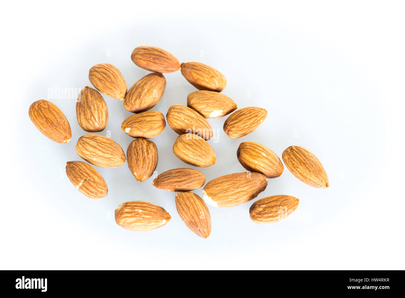 Delicacies almonds scattered on the white background Stock Photo - Alamy
