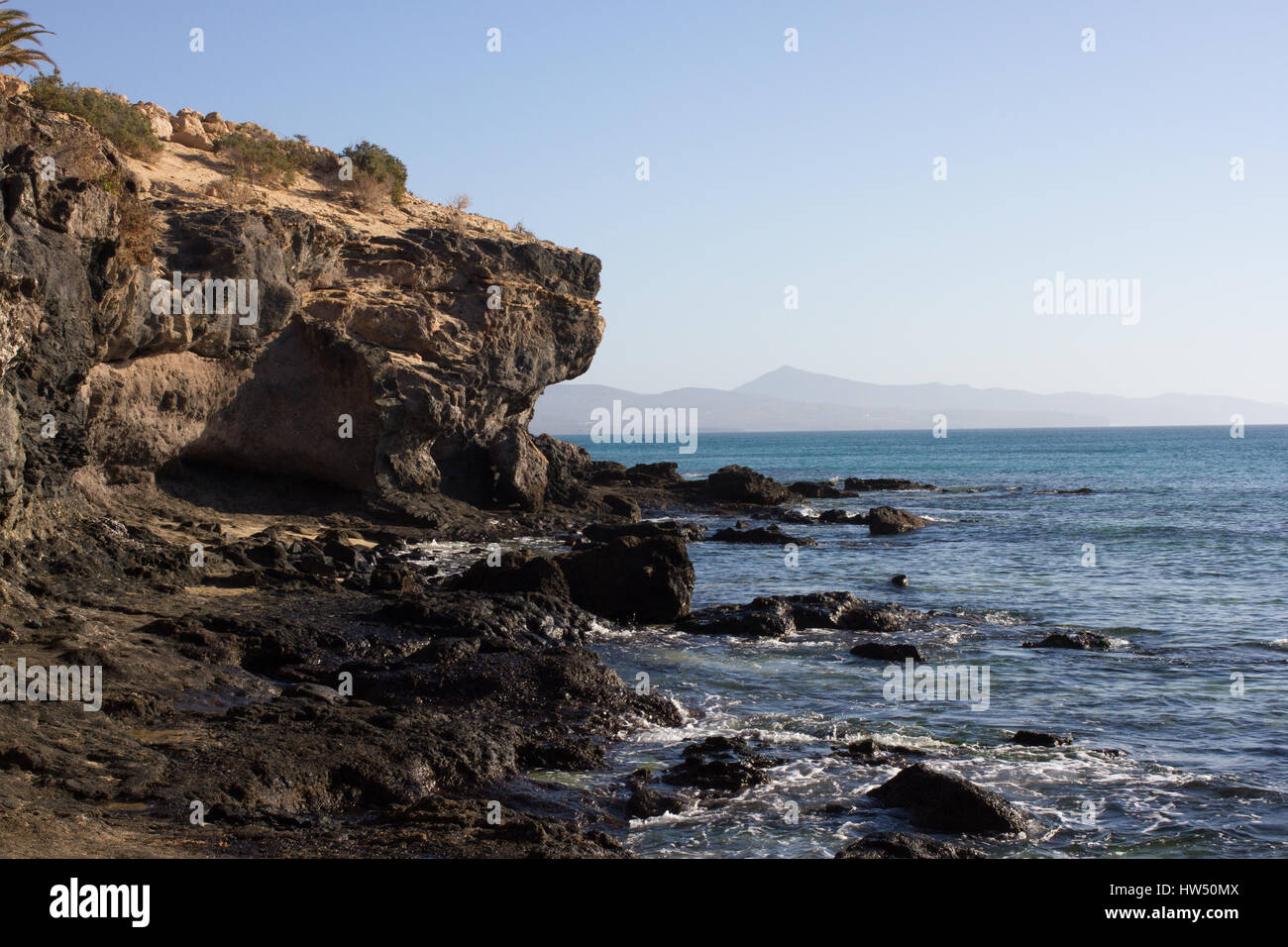 Black rocks of Costa Calma beach. Blue sea line. Playa Barca ...