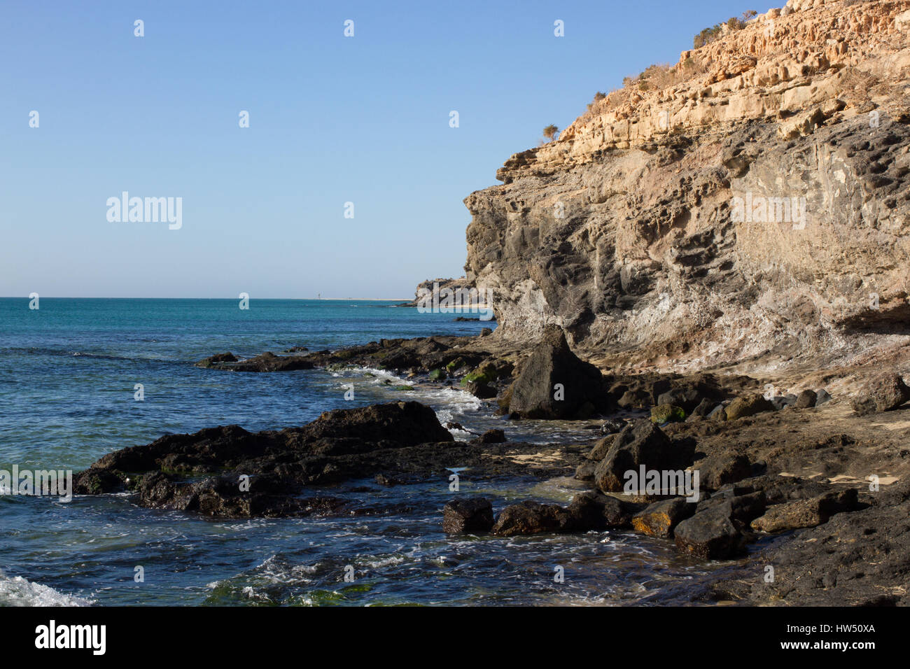 Black rocks of Costa Calma beach. Blue sea line. Playa Barca ...