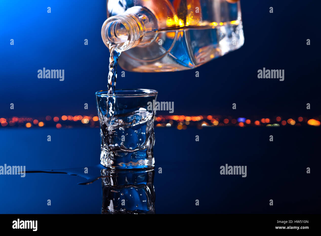 vodka in bar on a black reflective background Stock Photo - Alamy