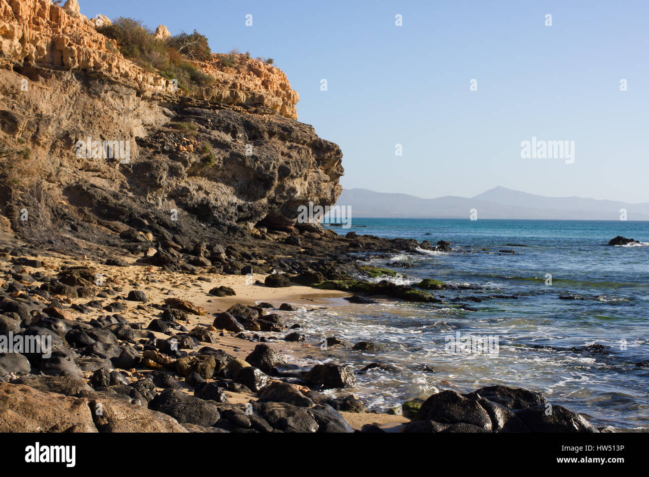 Black rocks of Costa Calma beach. Blue sea line. Playa Barca ...