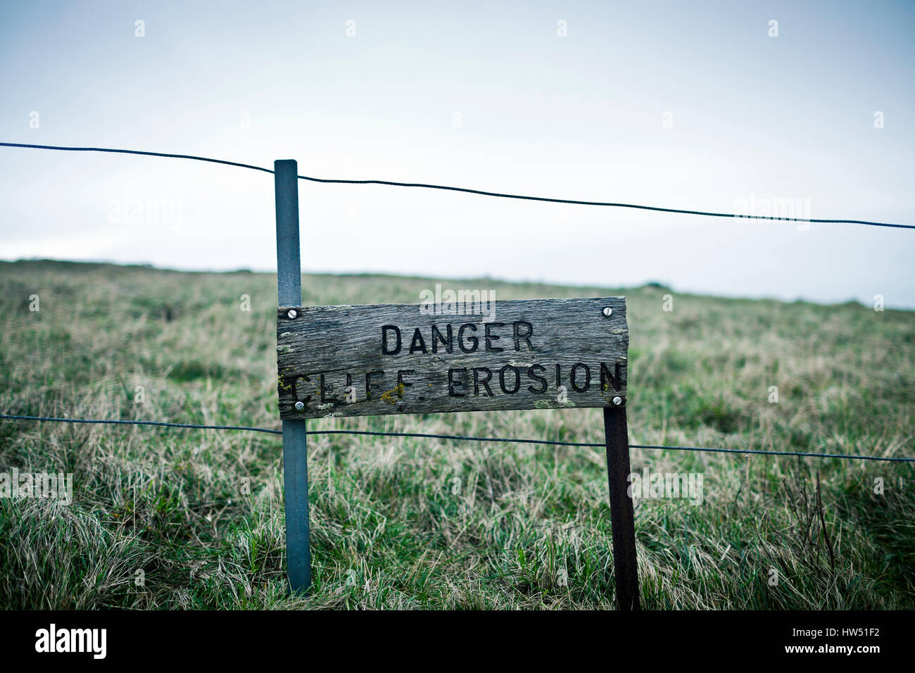 A sign informs visitors not to cross the line since the cliffs ends and ...