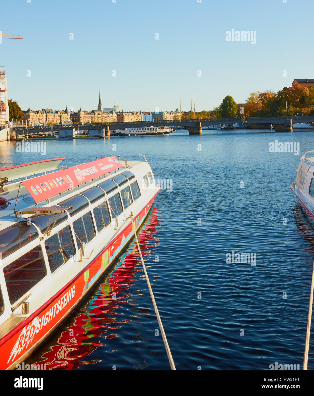 Sightseeing boats moored on Gamla Stan with Skeppsholmsbron Bridge in ...