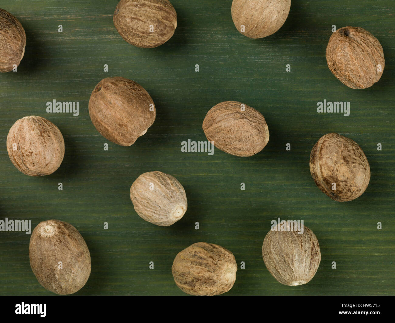 Whole Nutmeg Cooking Spice Against a Green Background Stock Photo - Alamy