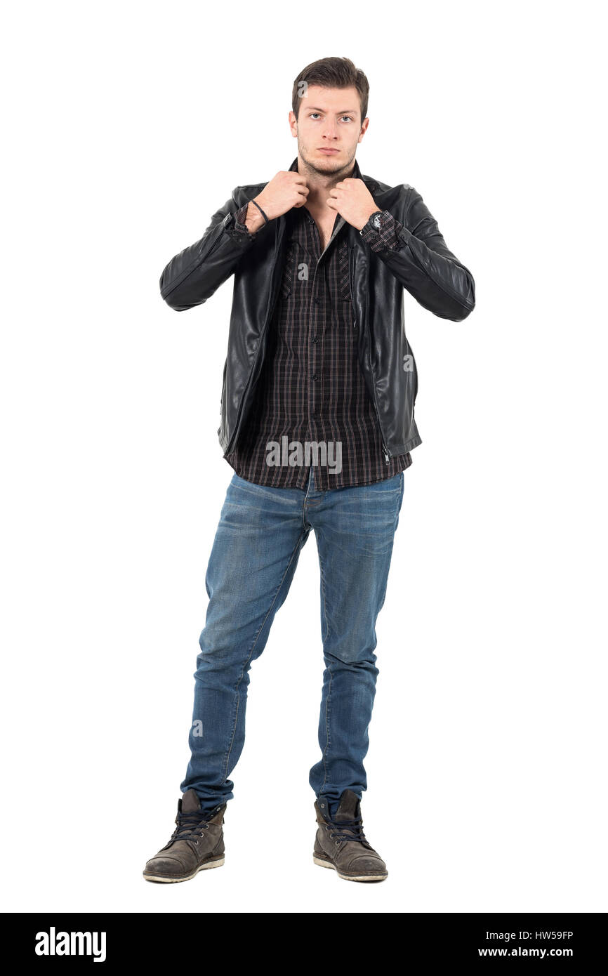 Handsome young man adjusting collar of black leather jacket looking at ...