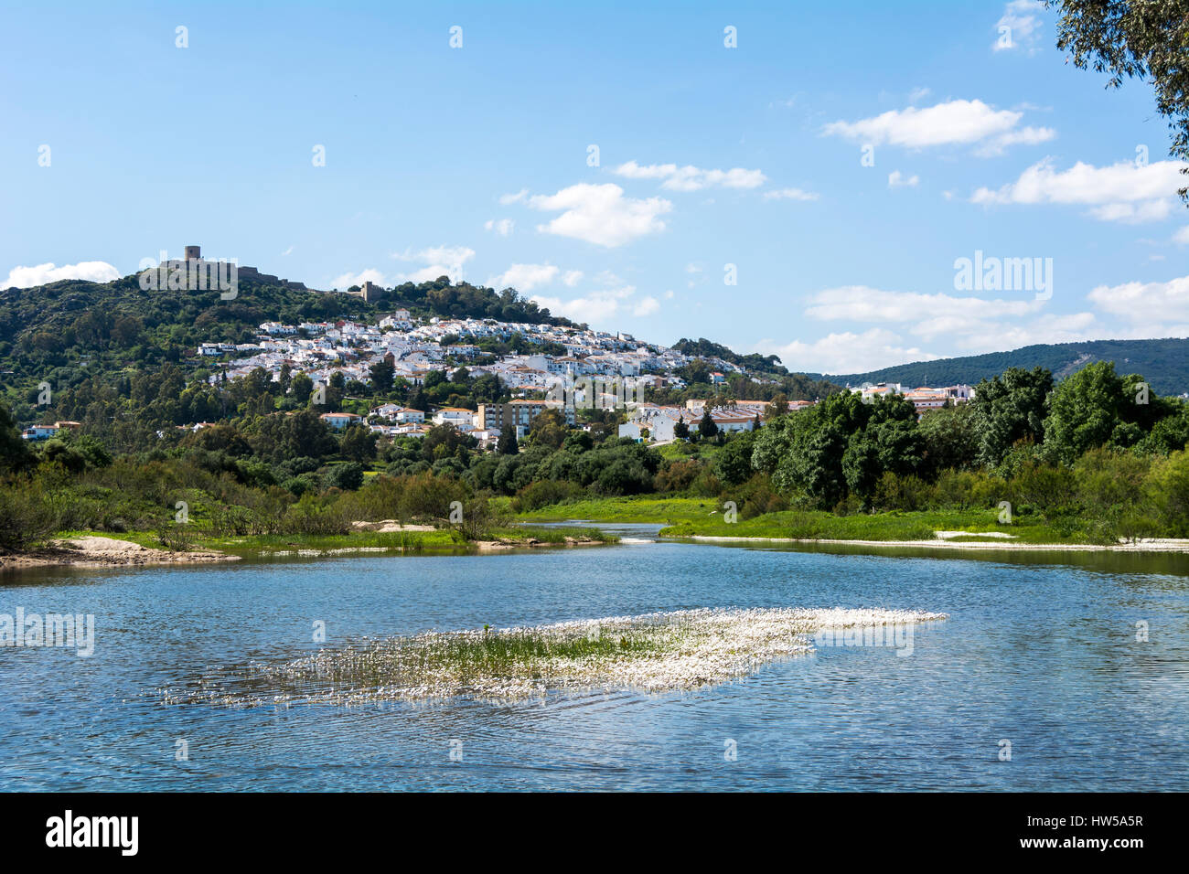 View from the river of a mountain village with a castle on top. Jimena ...