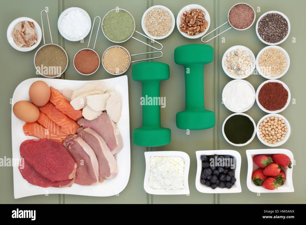 Super food for body builders with dumbells, meat, fish, fruit, dairy ...