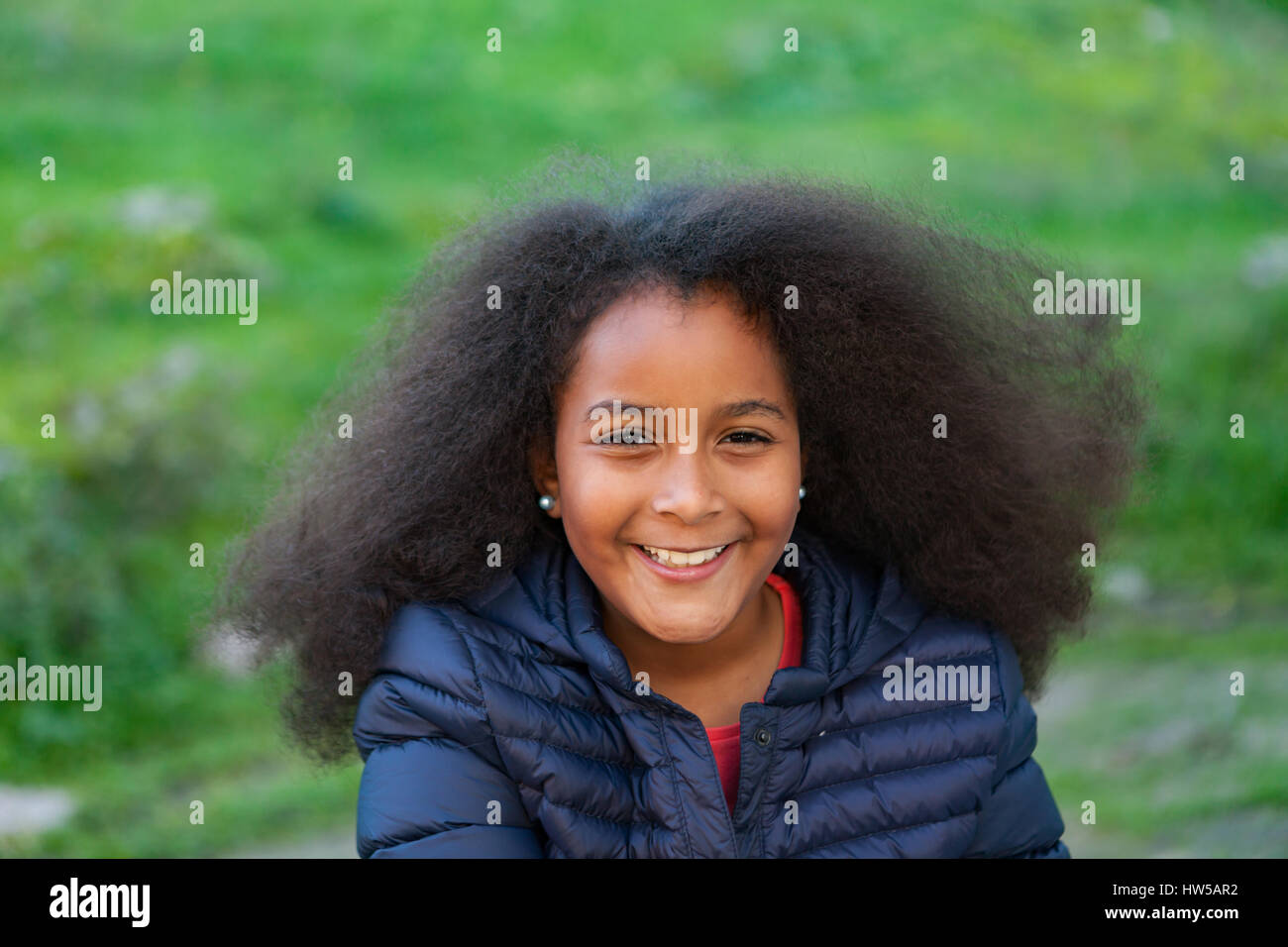 Pretty girl with long afro hair in the garden with a blue coat Stock ...