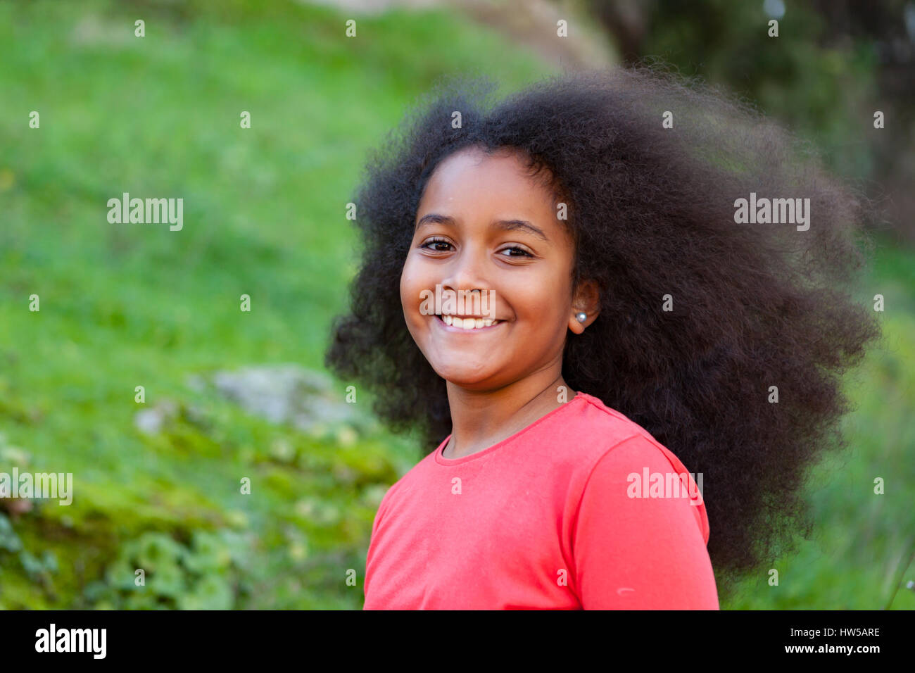 Pretty girl with long afro hair in the garden with a blue coat Stock ...