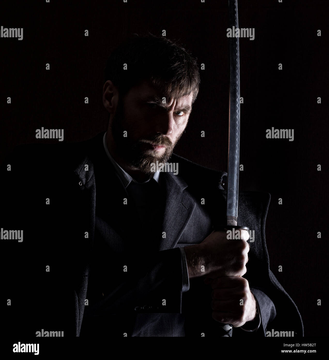 stern angry businessman in a wool coat with sword in dark background ...