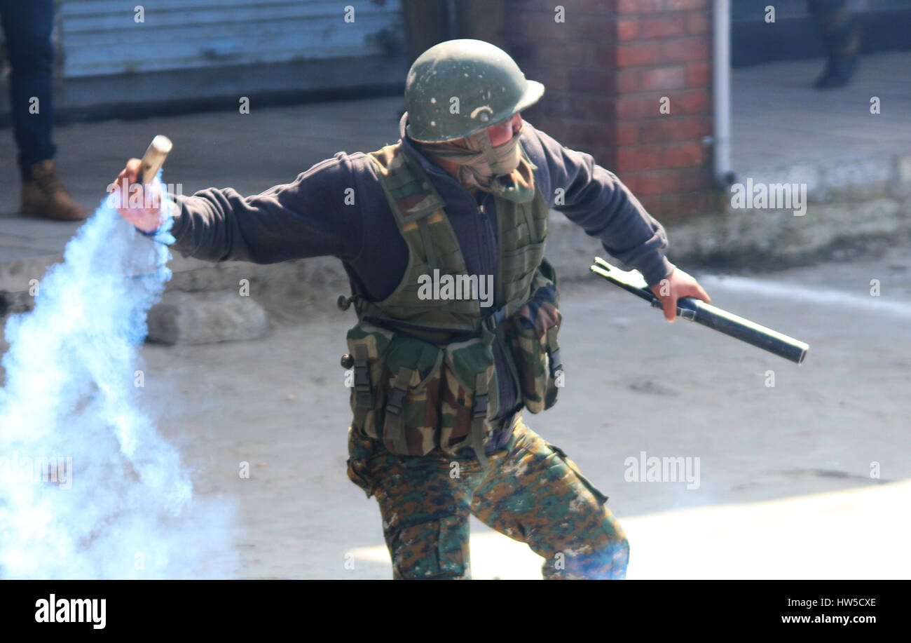 Srinagar, Kashmir. 17th Mar, 2017. Policeman throwing a tear smoke ...