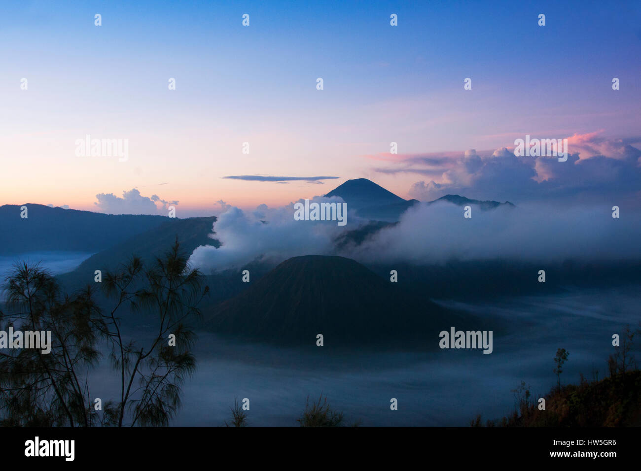 White smoke coming out of volcanoes surrounded by white clouds of mist ...