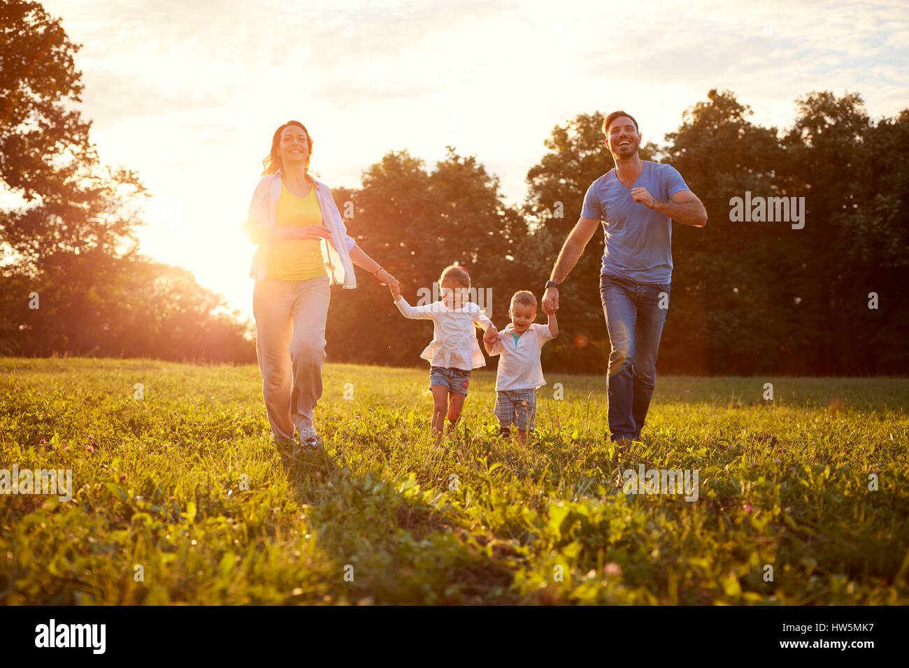Beautiful young family running together in nature Stock Photo - Alamy