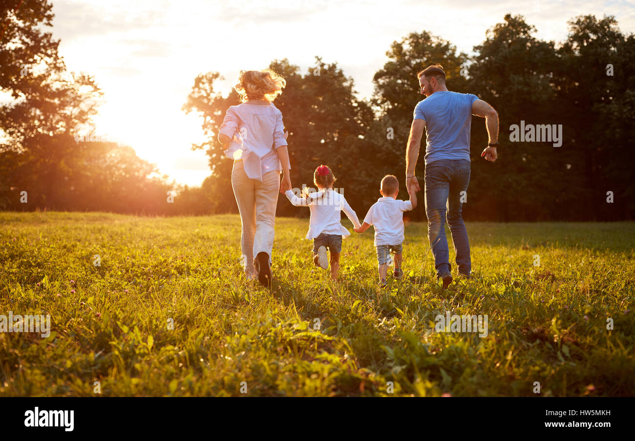 Family with children running together in nature, back view Stock Photo ...