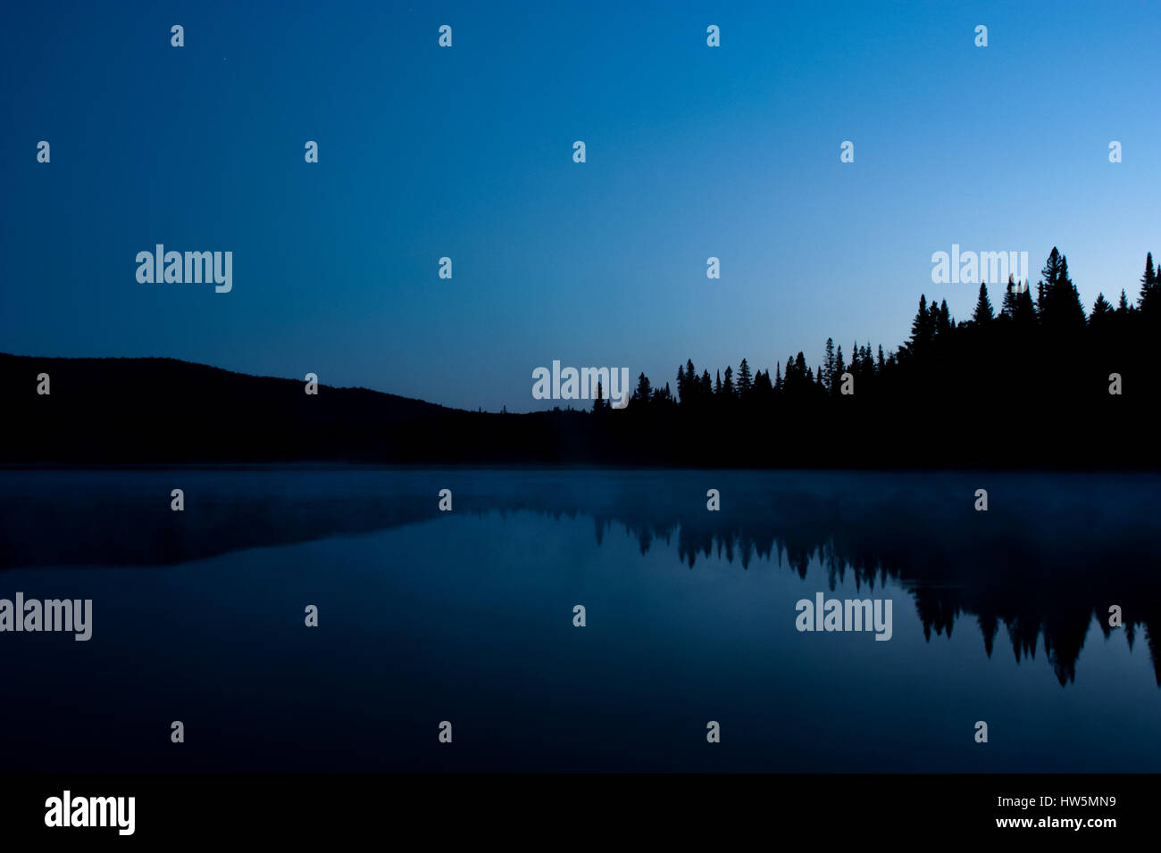 nighttime landscape with reflection on a lake Stock Photo - Alamy