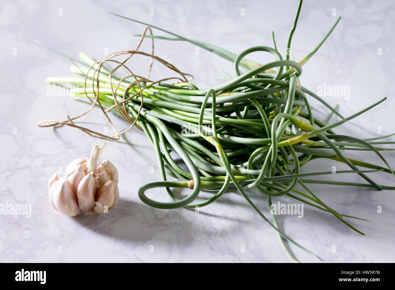 Harvest of fresh young garlic, garlic arrow on a stone background Stock ...