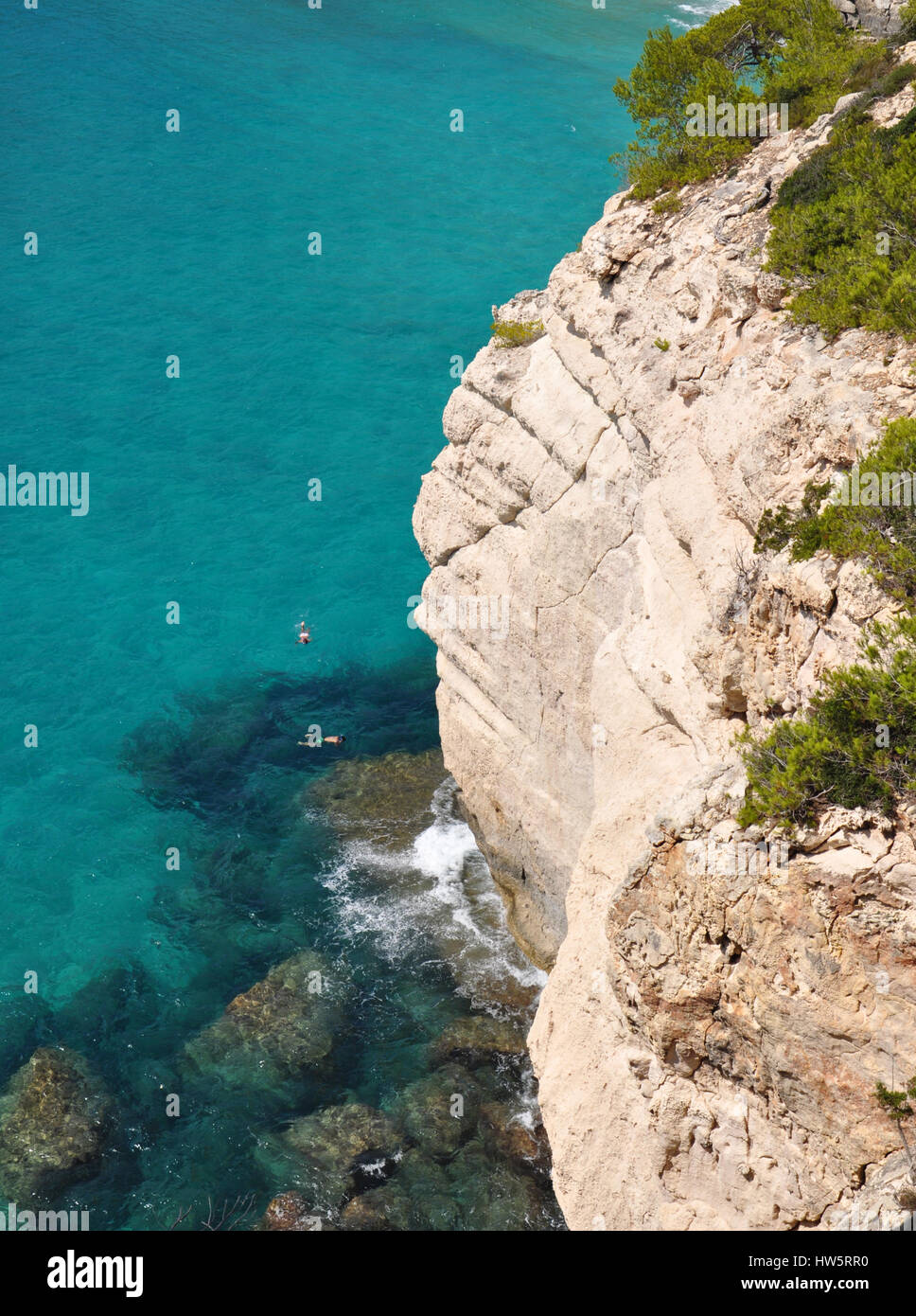 people swimming in transparent turquoise waters of balearic sea near ...