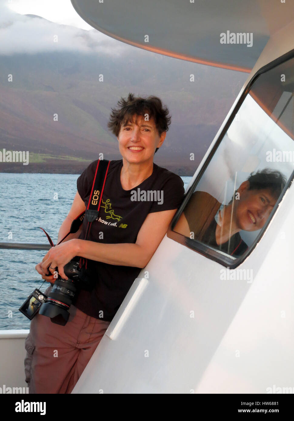 A solo female traveler poses on a yacht off the coast of the island of ...