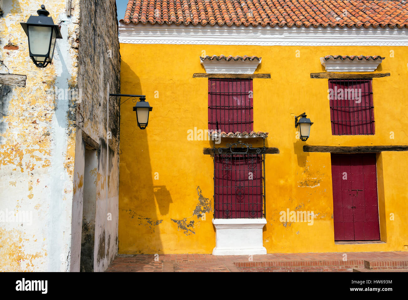 Yellow and red buildings with three street lights in colonial Mompox ...
