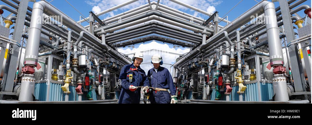 MODEL RELEASED. Oil refinery workers and pipework Stock Photo - Alamy