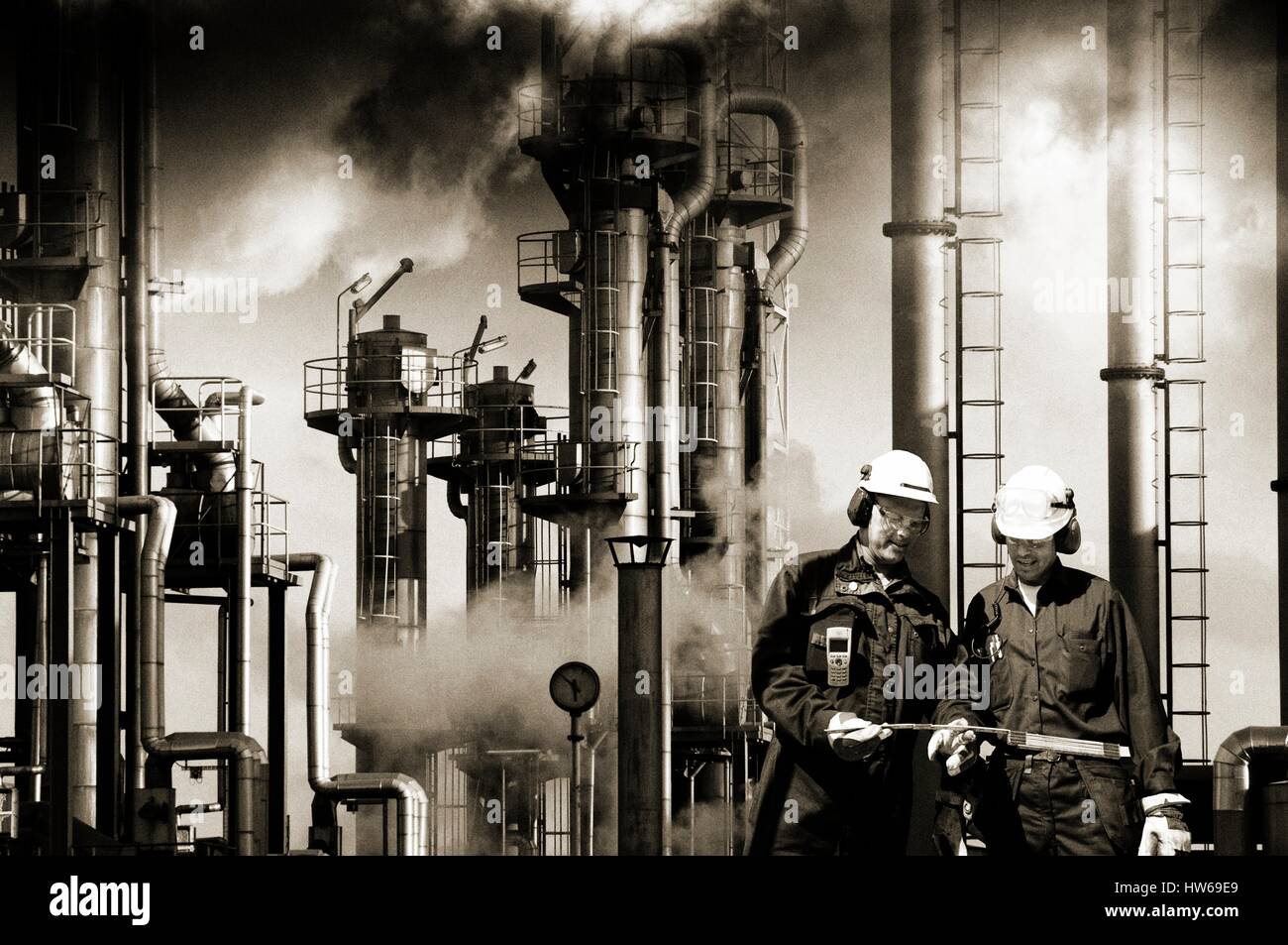 MODEL RELEASED. Oil refinery workers and pipework Stock Photo - Alamy