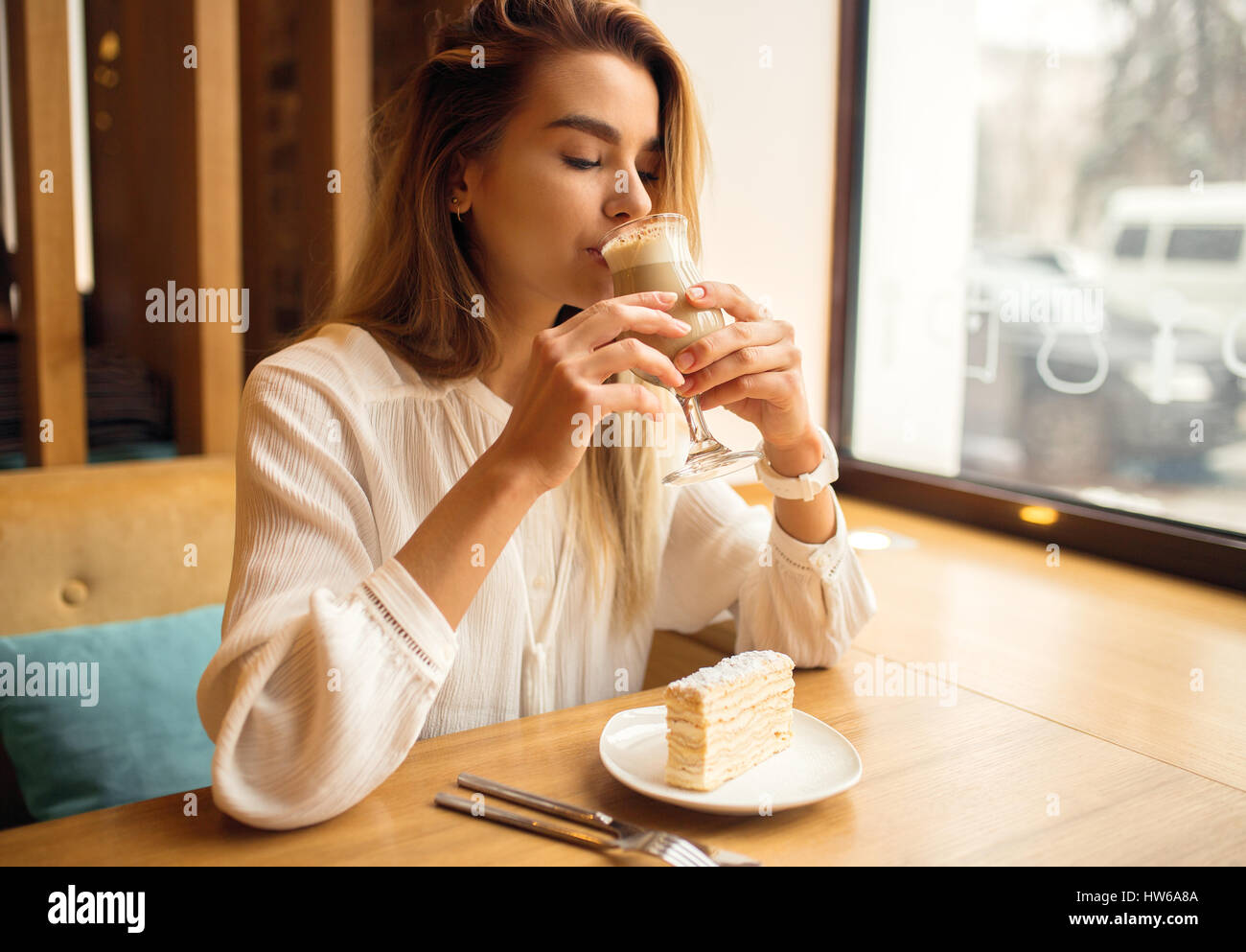 Young beautiful woman drinking latte in cafe Stock Photo - Alamy