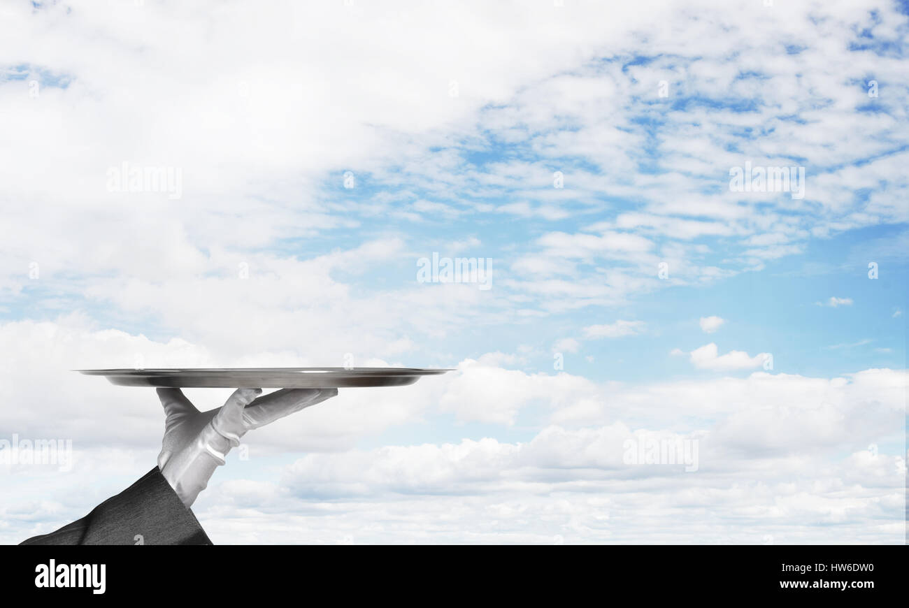 Waiter holding empty silver platter ready for product or item placement ...