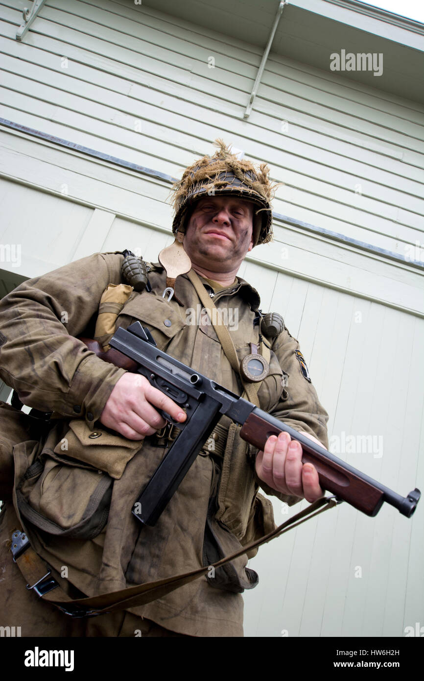 American ww2 soldier stands looking towards camera holding a Tommy ...
