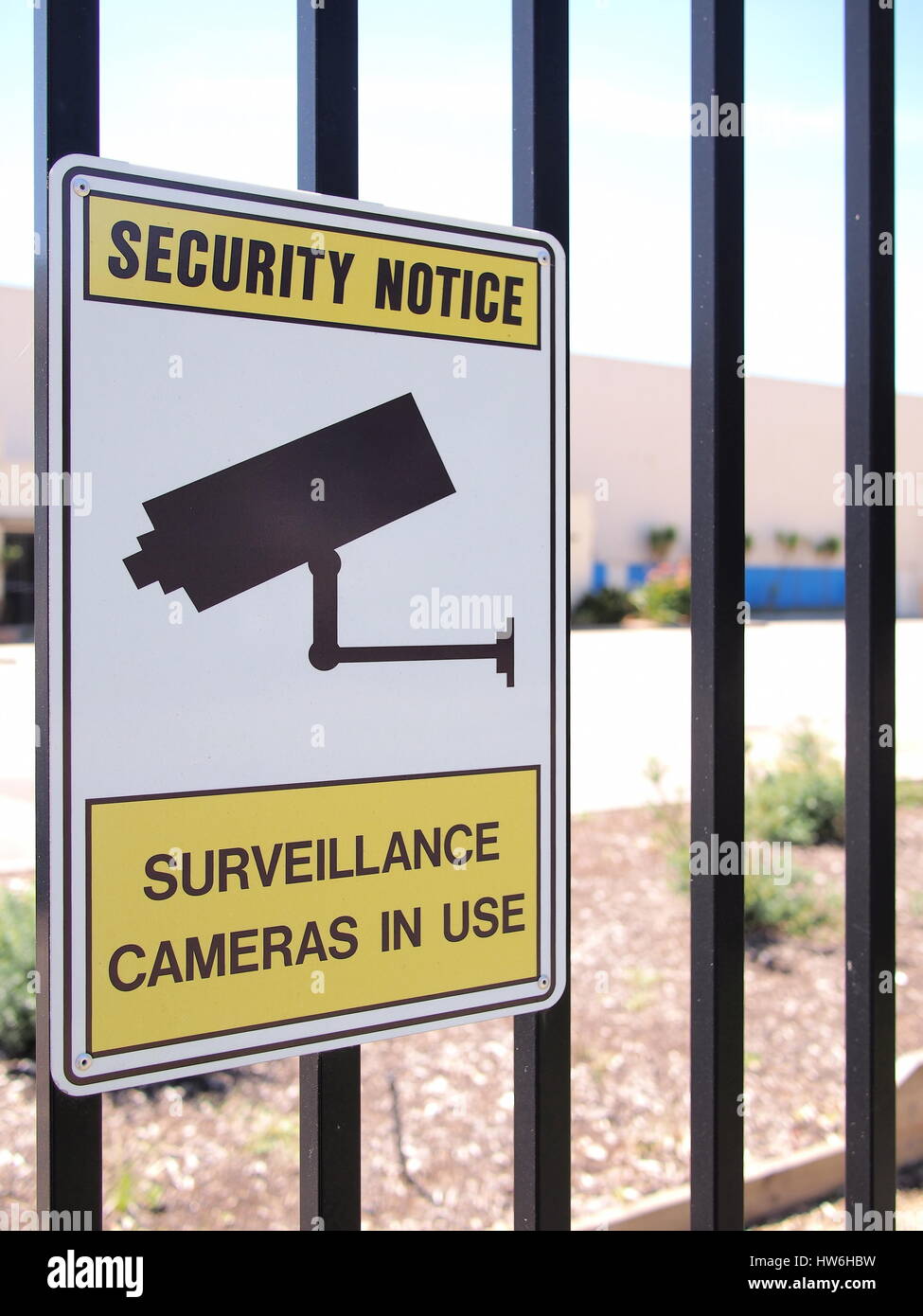 Camera surveillance sign on a steel fence of an industrial estate ...