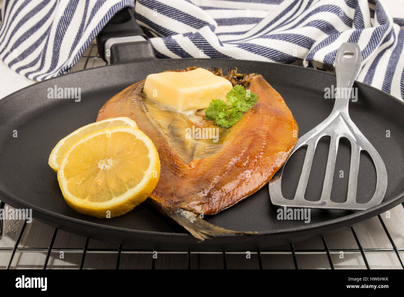 scottish smoked kipper with lemon, butter and parsley on a pan Stock ...