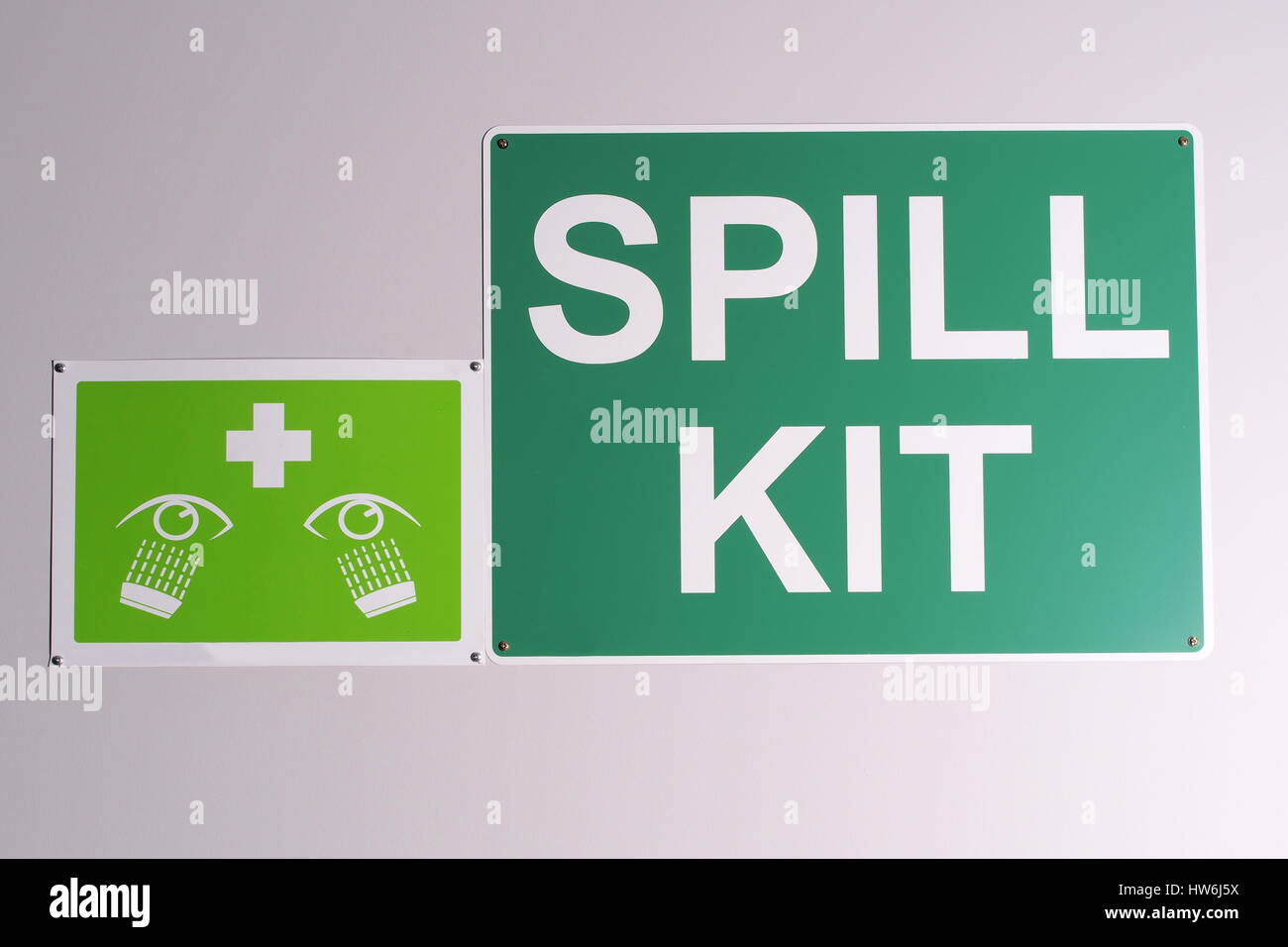 Emergency spill kit wall signs in green on off white background on a ...