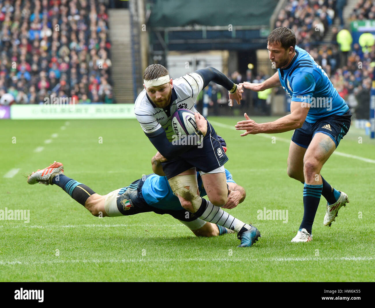Scotland's Finn Russell bursts through the tackle of Italy's Angelo ...