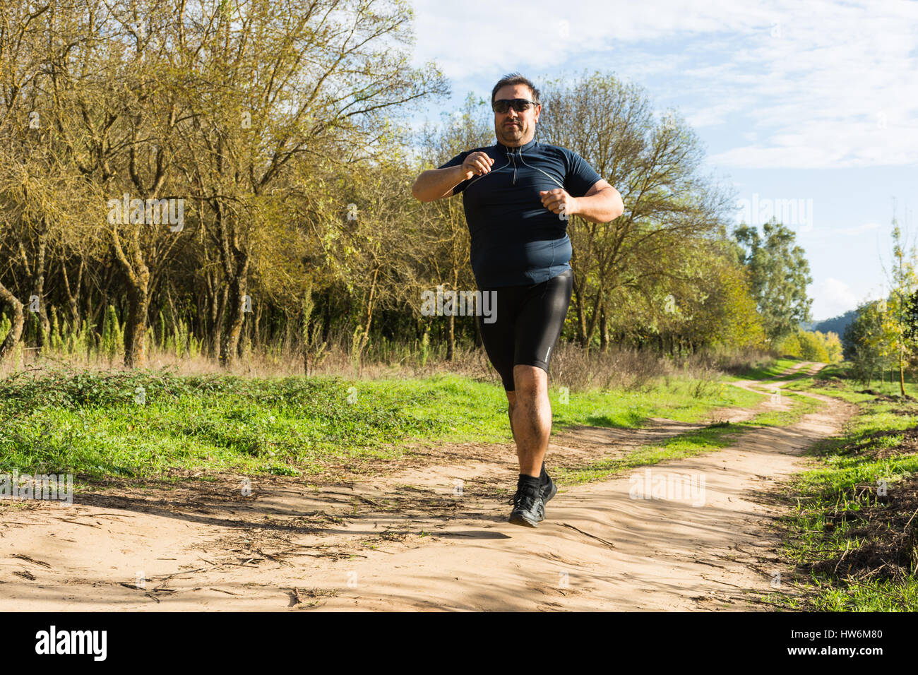 Big belly man jogging , exercising, doing cardio in the park , slightly ...