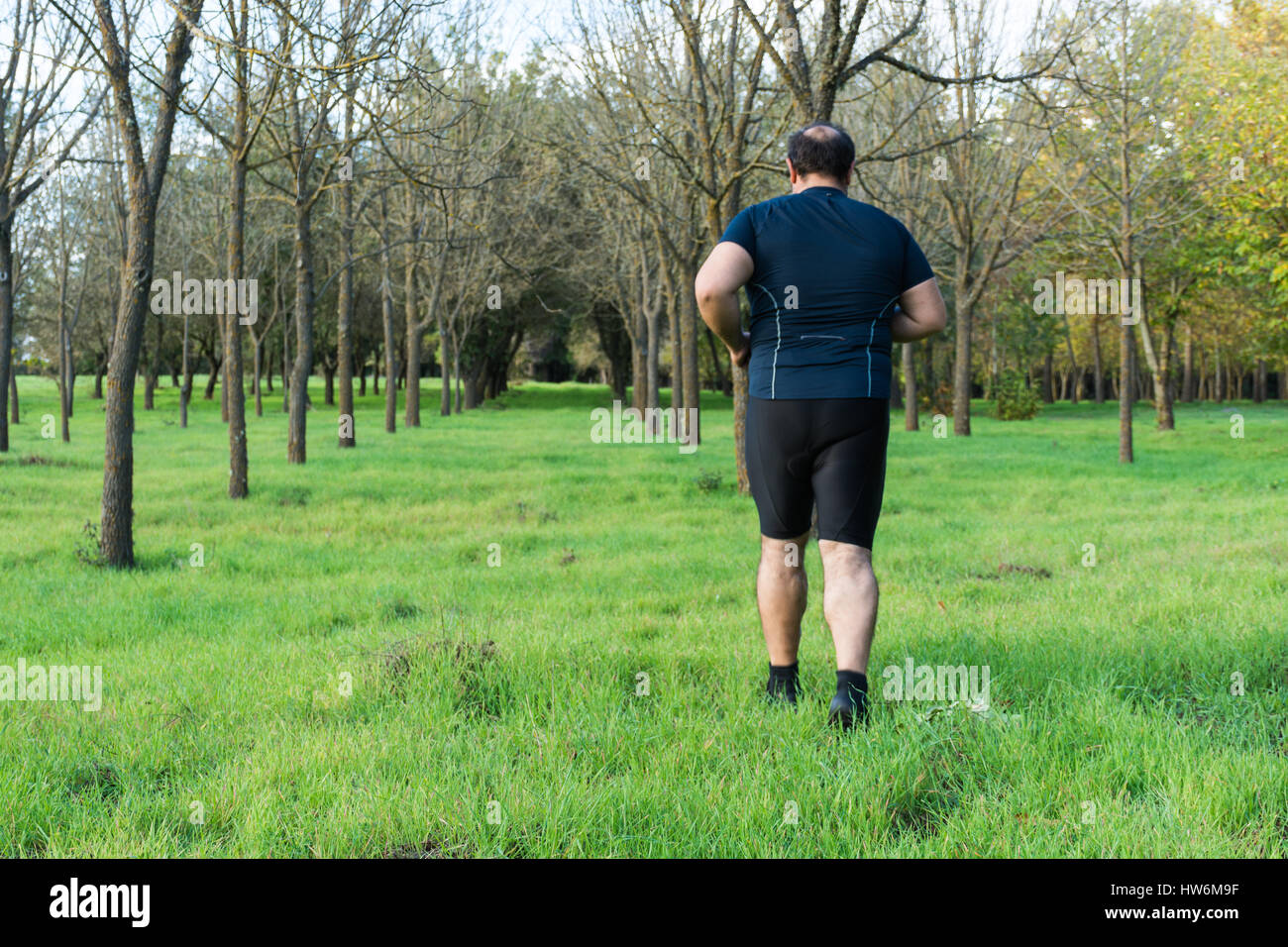 Big belly man jogging , exercising, doing cardio in the park , slightly ...