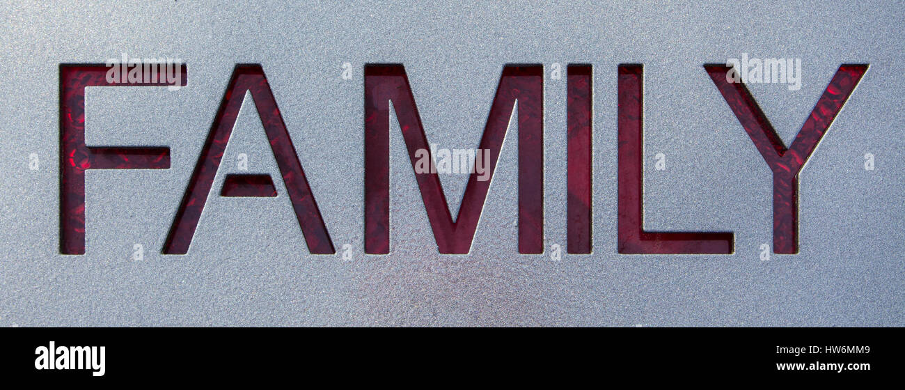 Nice red lettering into a sandy metal surface, spelling Family Stock ...