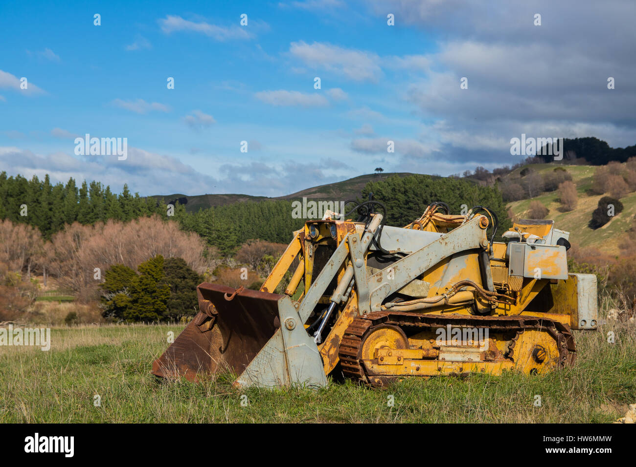 Yellow and grey bulldozer parked in a farm valley Stock Photo - Alamy