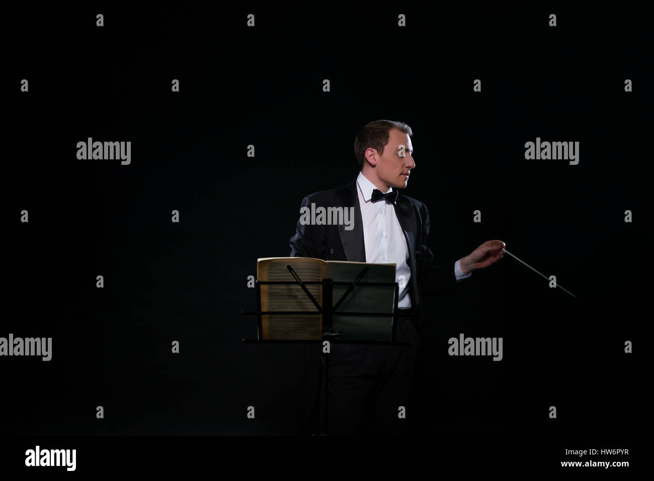 Orchestra conductor in black tuxedo in dark studio Stock Photo - Alamy