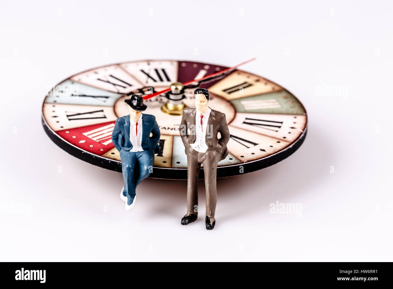 model of man sitting on beautiful old clock on white Stock Photo - Alamy